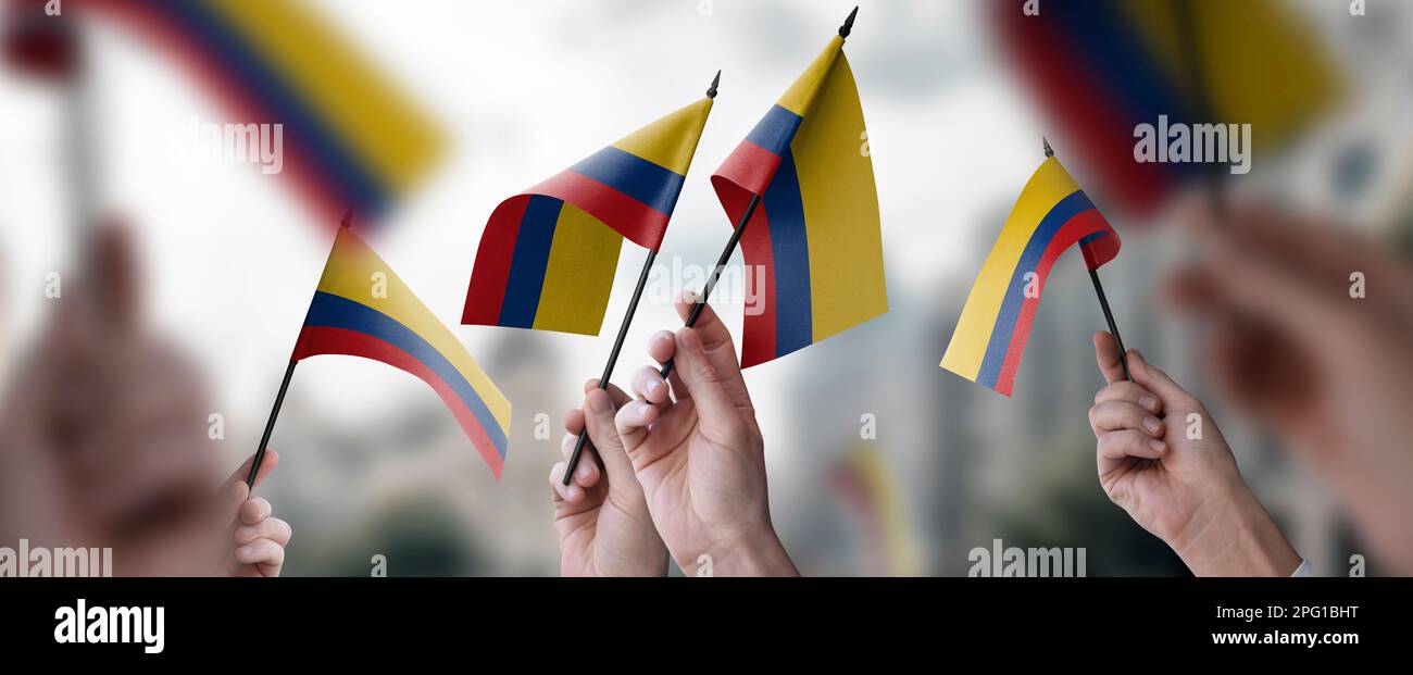 A group of people holding small flags of the Colombia in their hands ...