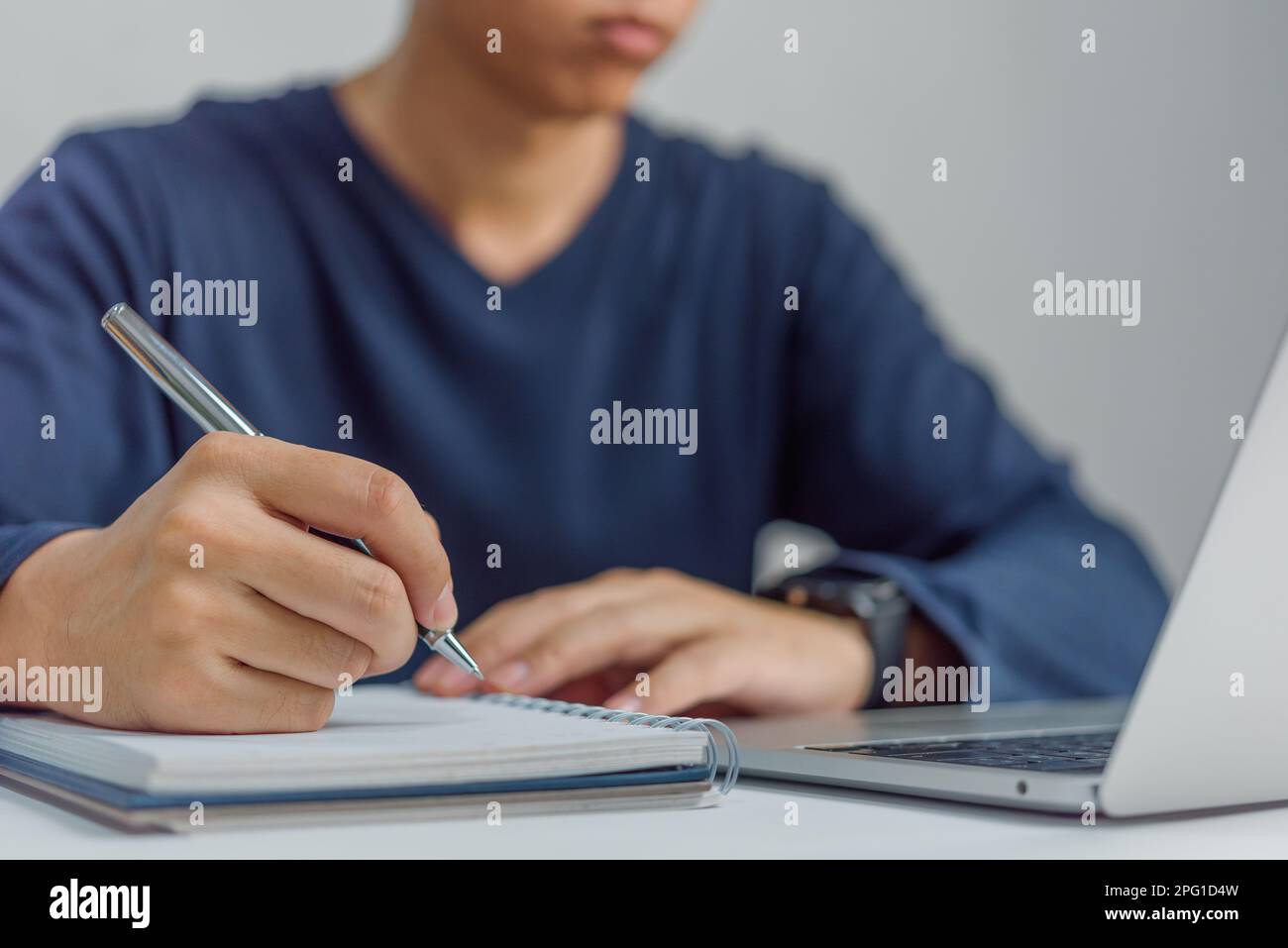 learning online class by using laptop computer and writing notebook at ...