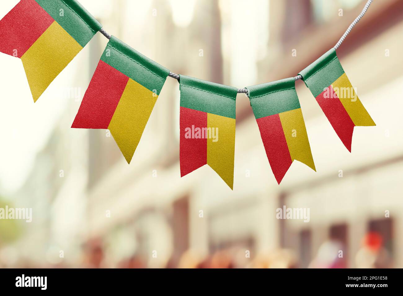 A garland of Benin national flags on an abstract blurred background ...