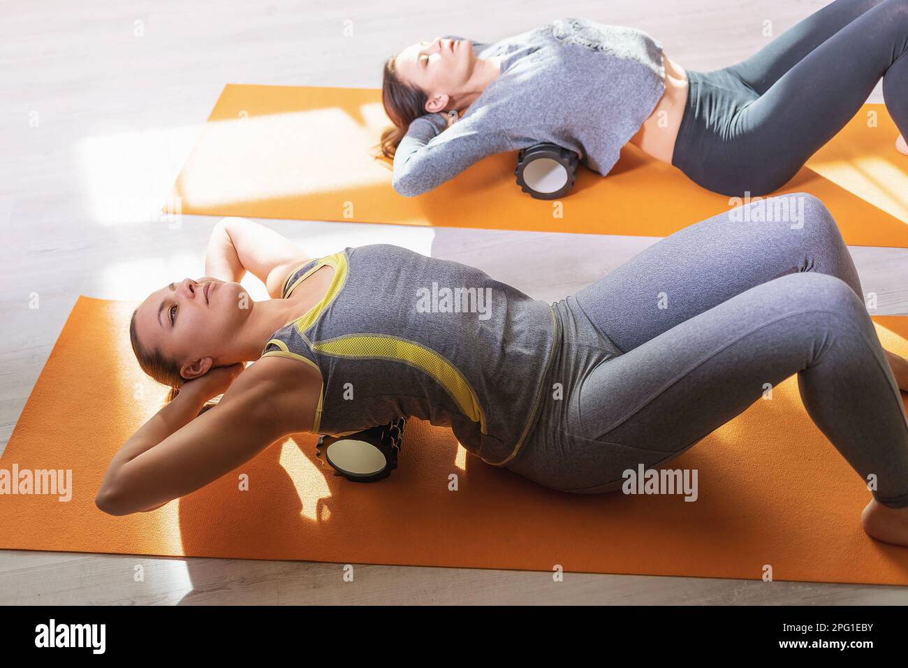 Women in sportswear perform myofascial relaxation of hyperactive back ...