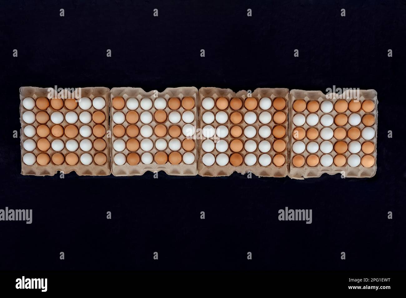 The inscription EASTER is lined with brown eggs top view. Hundreds of white eggs in paper trays ...