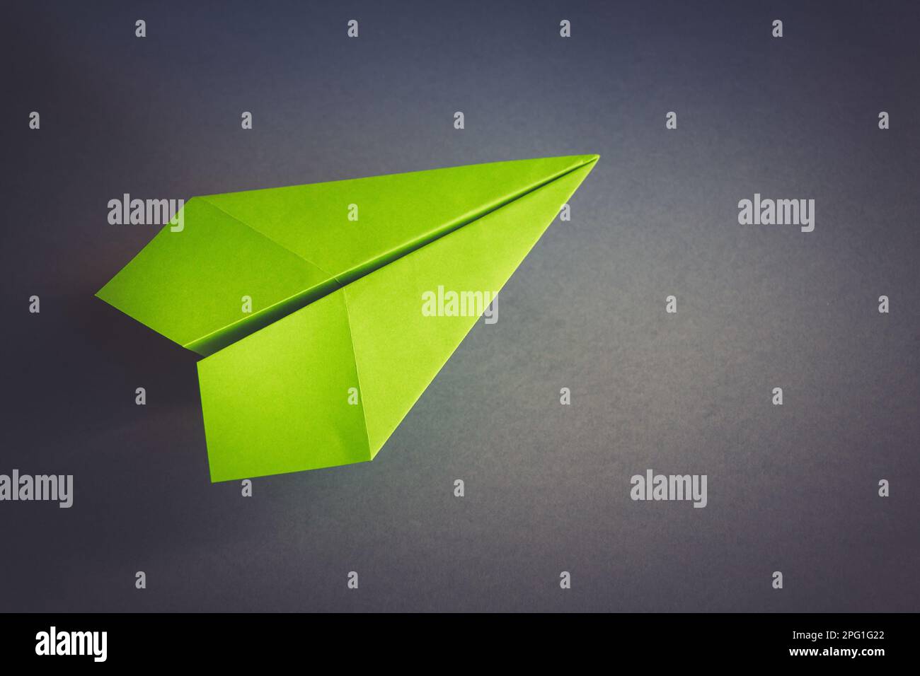 Green paper plane origami isolated on a blank grey background Stock ...