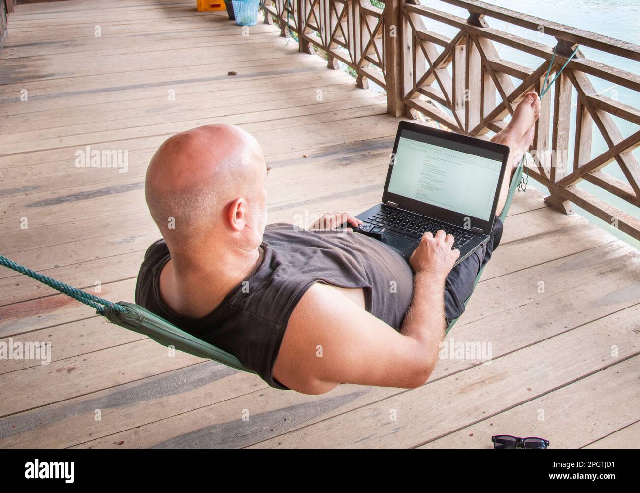 Working remotely on his computer in Si Phan Don,Southern Laos,whilst ...