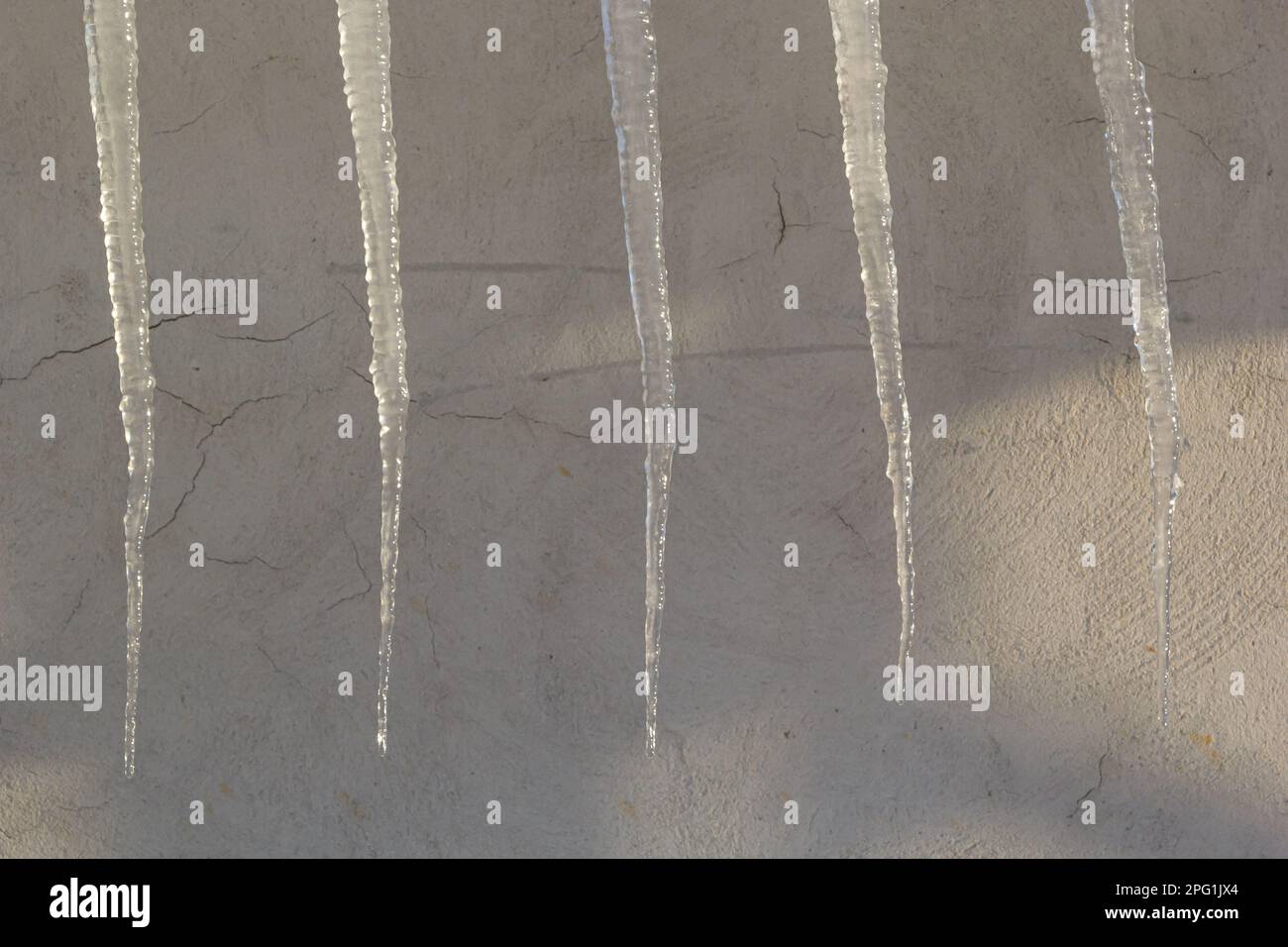 Sharp icicles and melted snow hanging from eaves of roof. Beautiful ...
