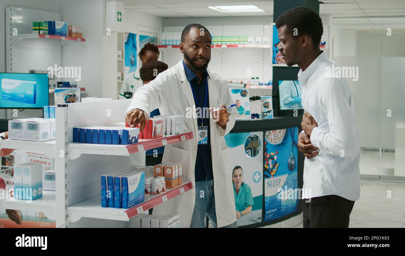Pharmacist talking to patients in store hi-res stock photography and ...
