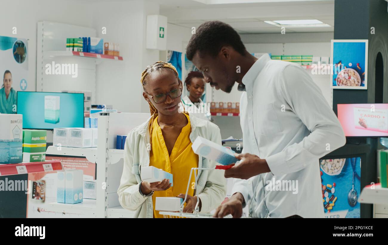 African american client asking pharmacist for advice, talking about ...
