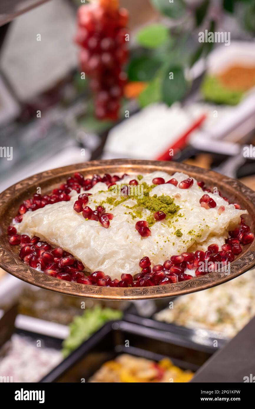 Gullac dessert. Ramadan dessert. Waiter holding gullac garnished with ...