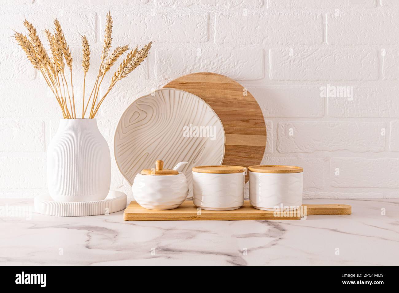 front view of beautiful kitchen utensils and a white vase with ears of ...