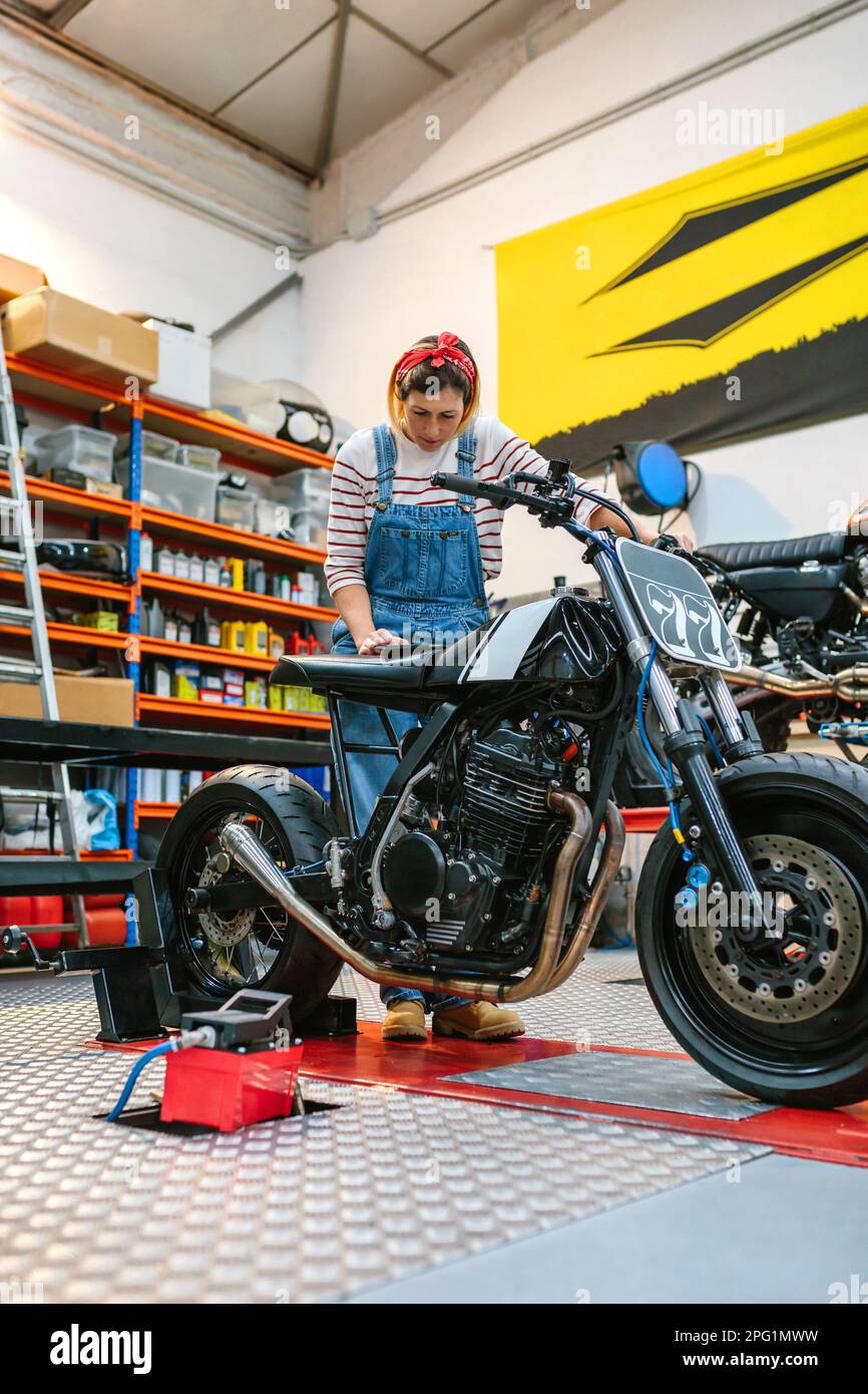 Mechanic with digital tablet checking motorbike on workshop Stock Photo ...