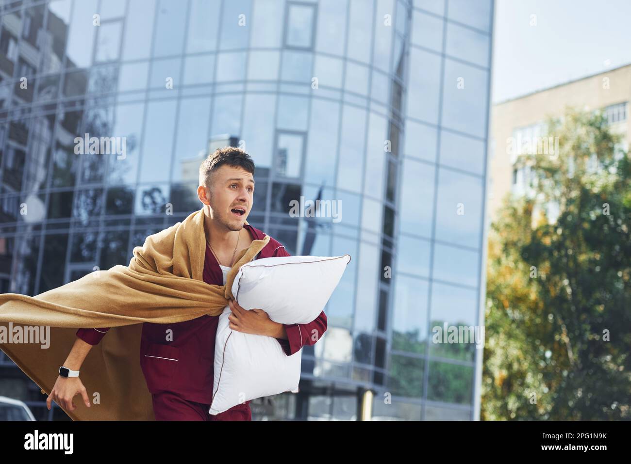 Running, late for the work. Young man in pajama is outdoors on the ...