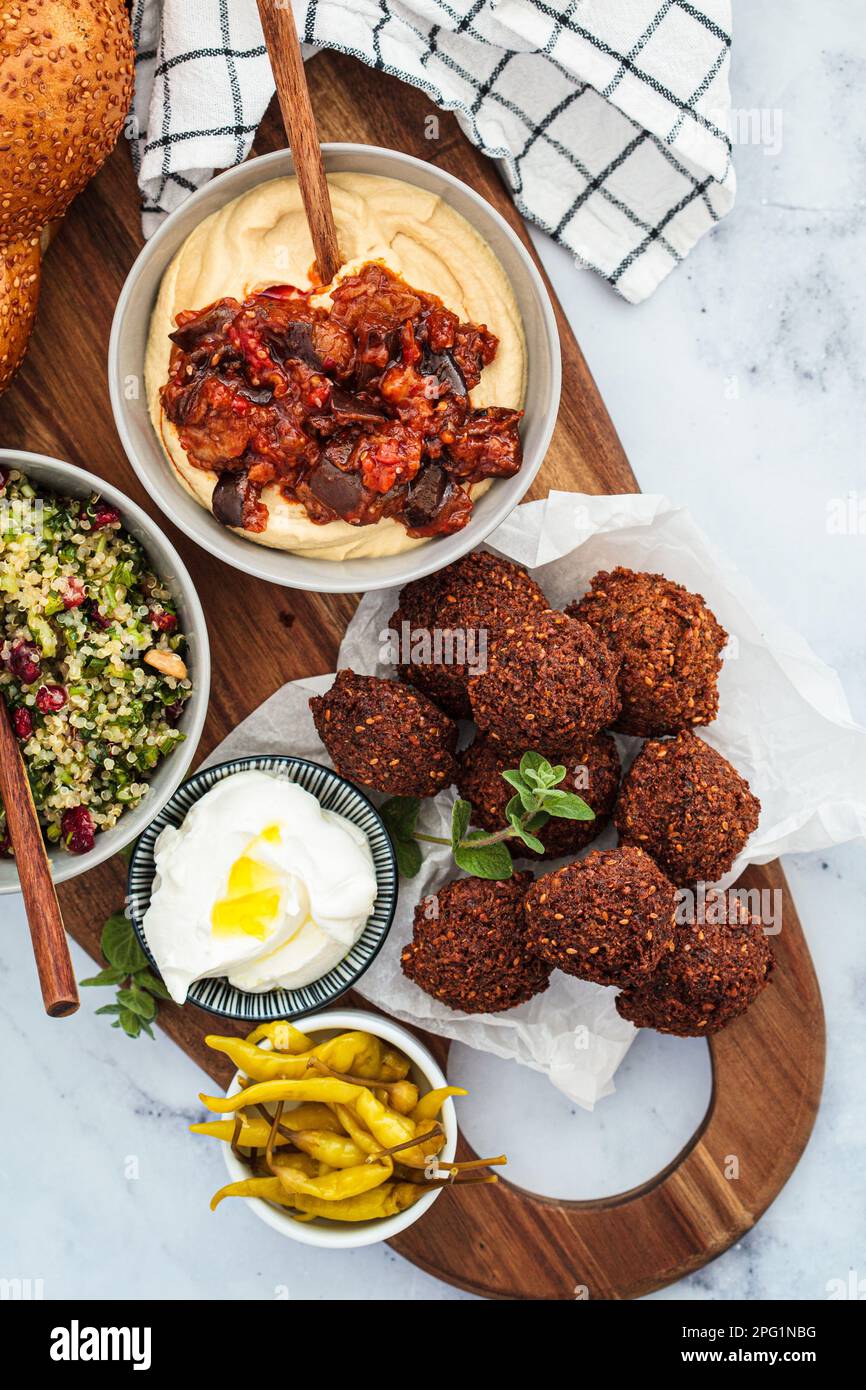 Traditional Shabbat table: challah bread, falafel, quinoa salad, hummus ...