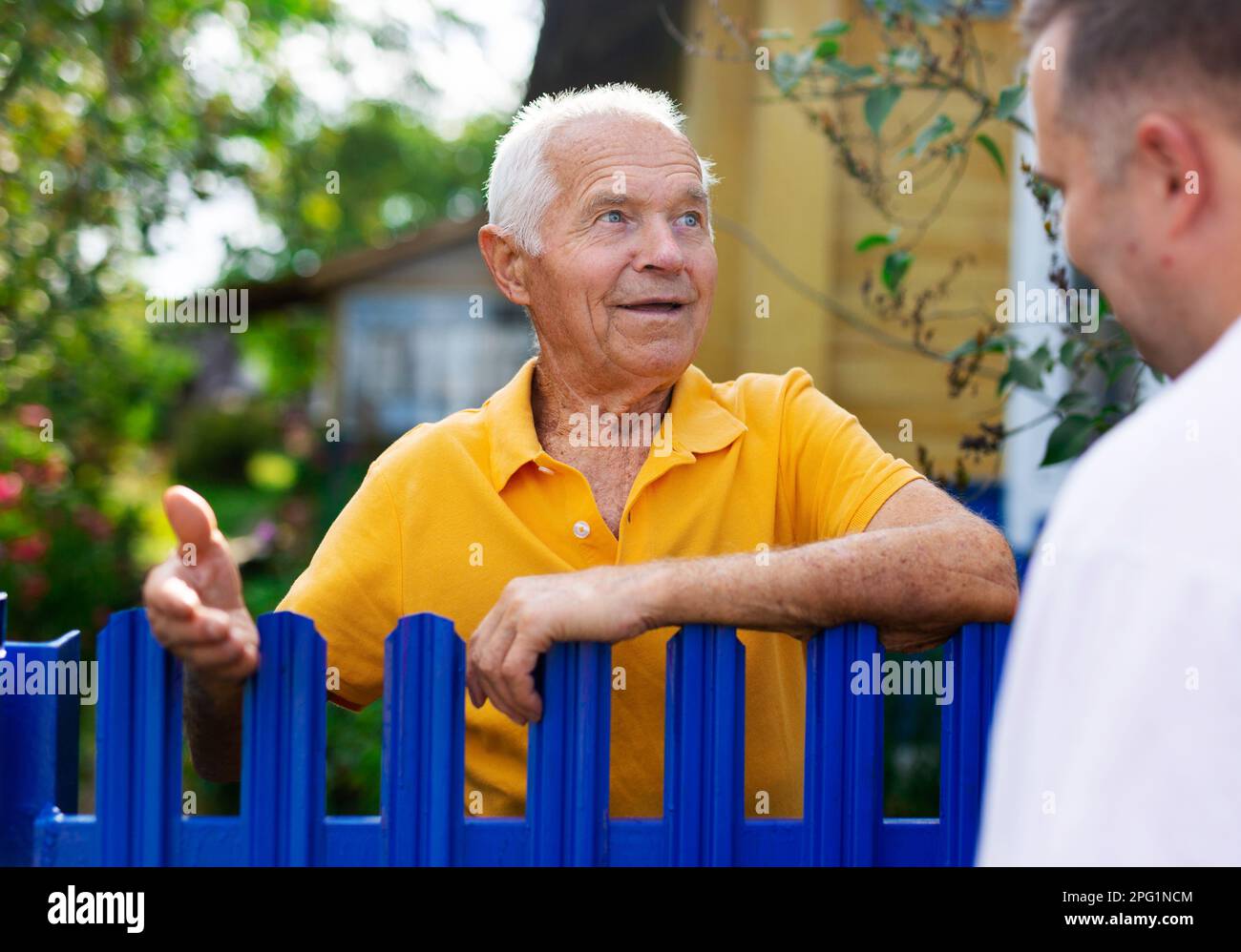 Good neighbors talk on border of their farms Stock Photo - Alamy