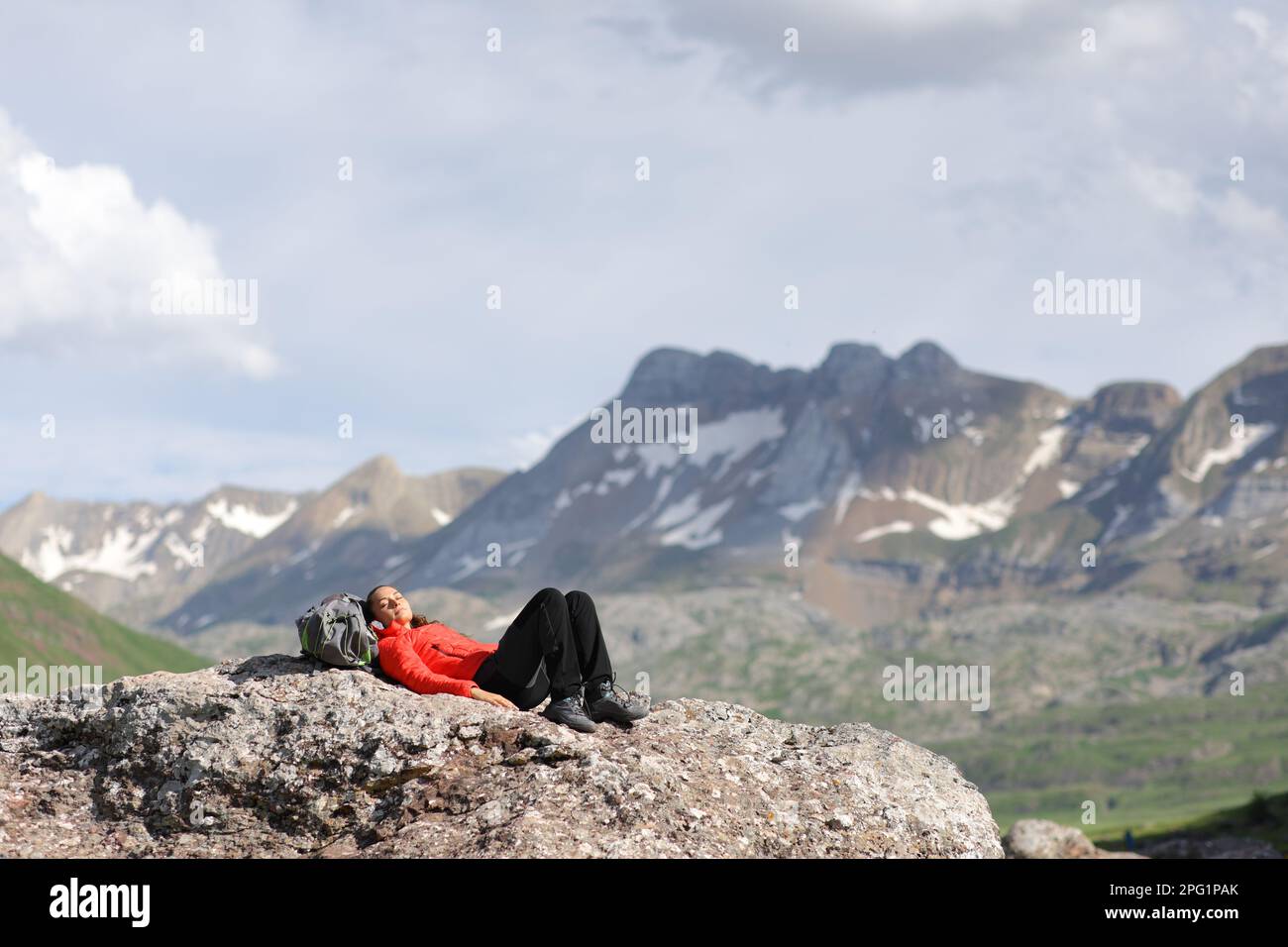Hiker resting on the top of a mountain lying on a rock Stock Photo - Alamy