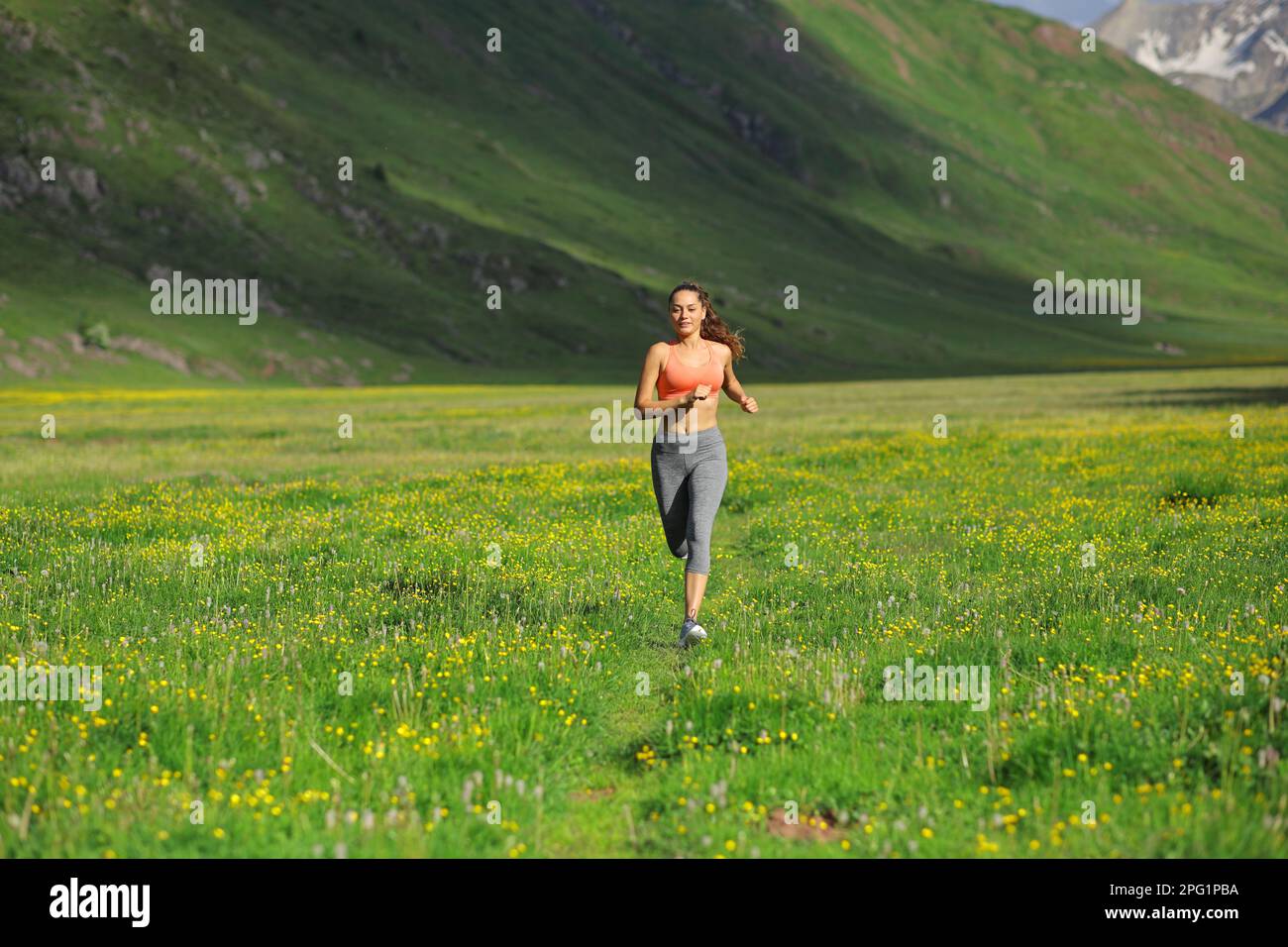 Front view of a runner running in a valley in nature Stock Photo - Alamy