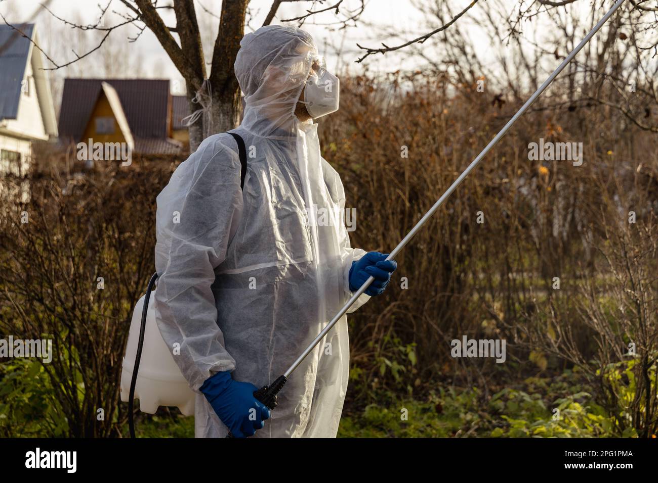 Using chemicals in the garden orchard gardener applying an insecticide ...