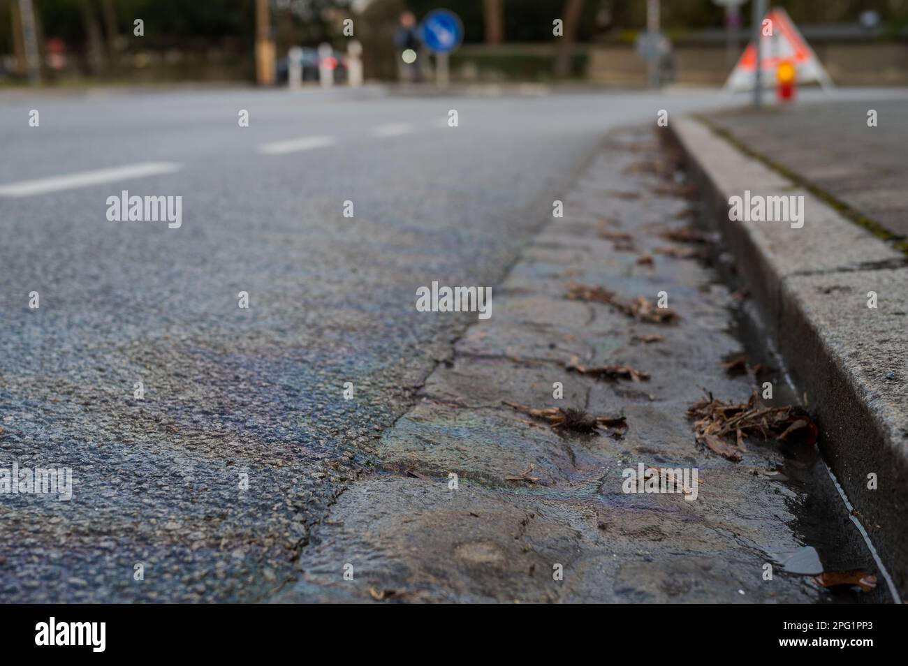Shimmery and shiny trail and puddle of oil, gasoline or Diesel on the ...