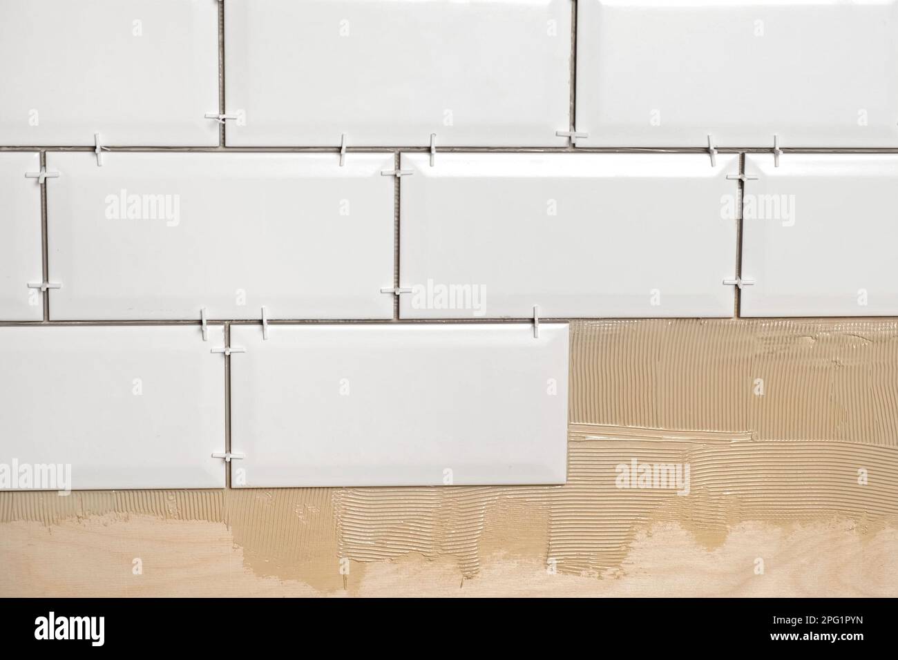 Male Worker Master Laying Ceramic Tiles on the Wall of Kitchen ...