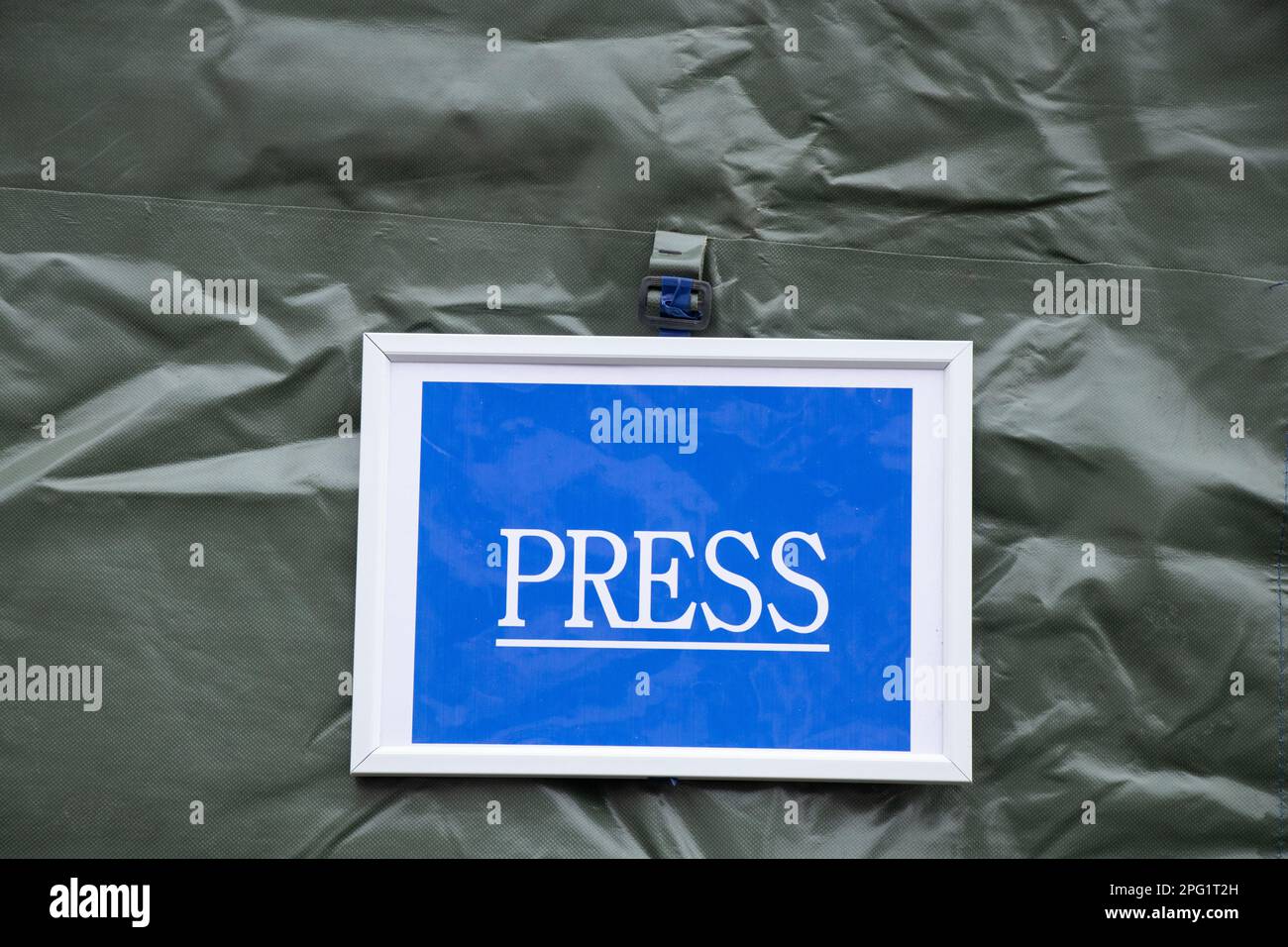 The word press on a blue sign at the entrance to the tent with press ...