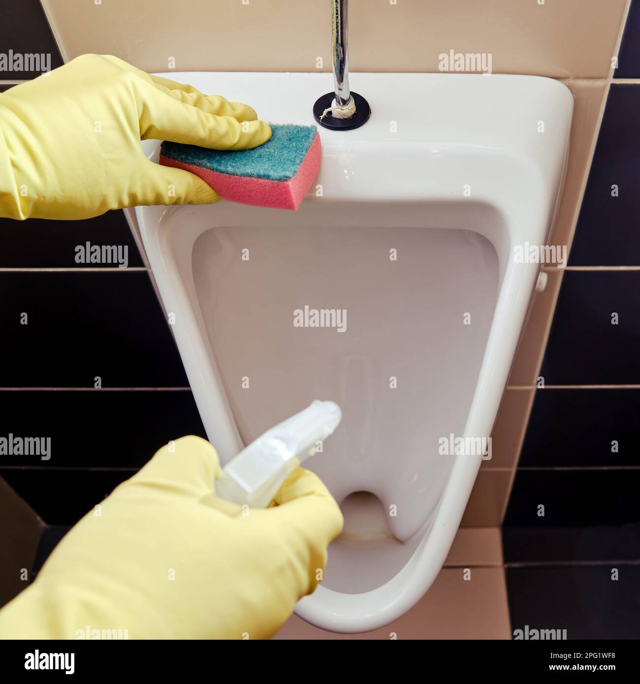 Cleaning in a public toilet restaurant, a man hand in yellow gloves ...