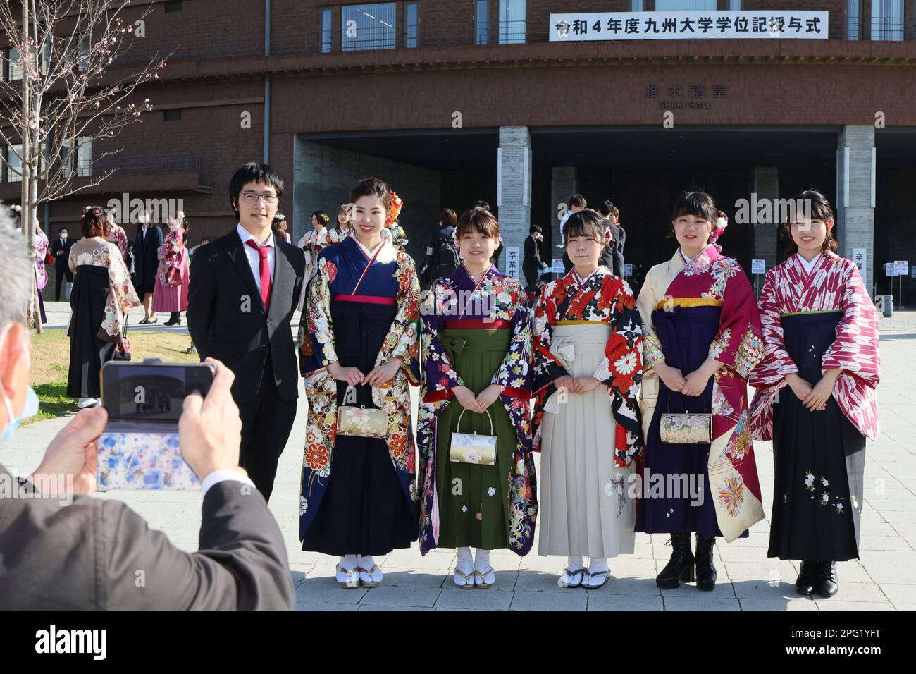 Students take pictures during the graduation ceremony at Kyushu ...