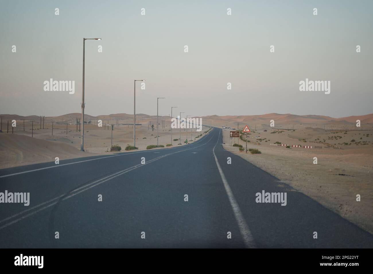 Asphalt road among the desert with traffic signs Stock Photo - Alamy