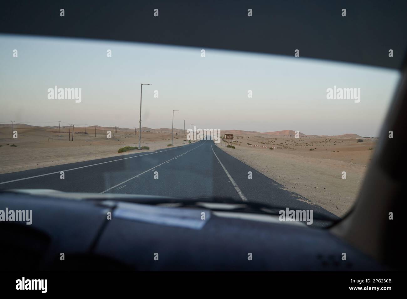 View from the car window on a paved road in the middle of the desert ...