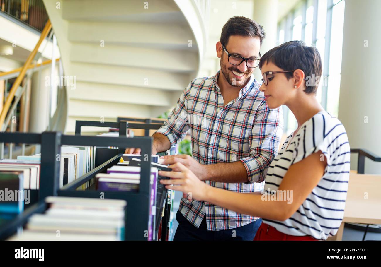 Students studying in library. Young success people are spending time ...