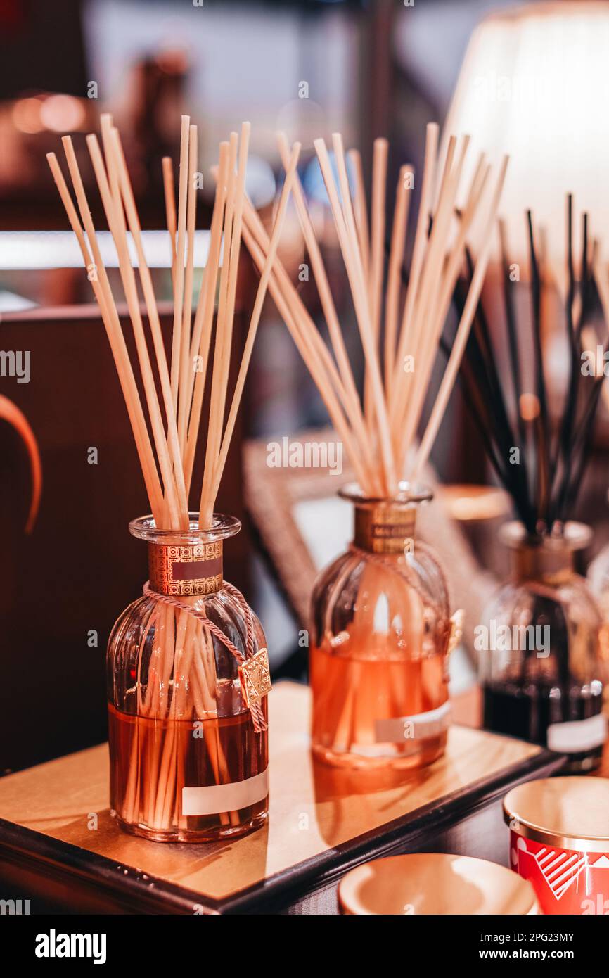Mockup glass bottle with aroma sticks diffusers on wooden stand in the shopping mall. Home ...