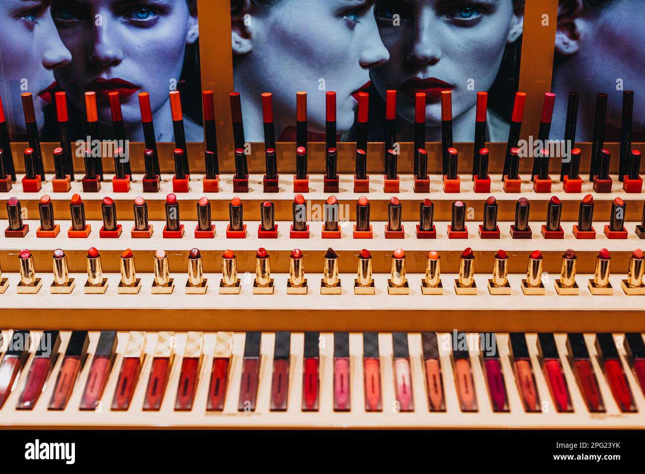 Set red pink glossy lipsticks on a stand. Background for branding and ...