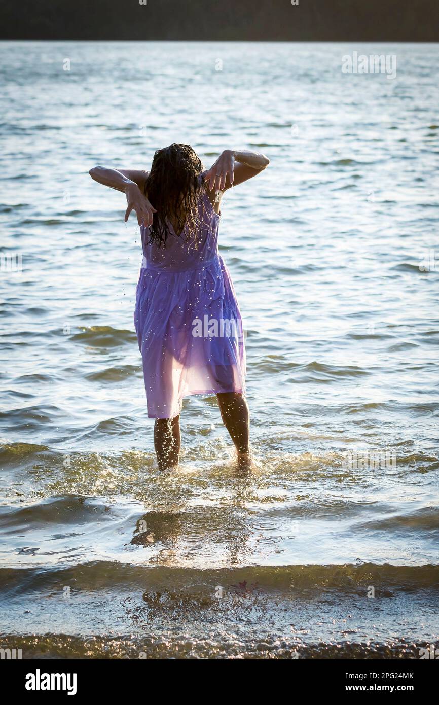 Woman in white dress dancing in water Stock Photo - Alamy