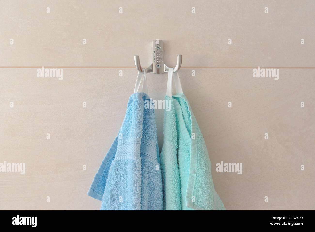 Blue and turquoise towels hanging on the bathroom wall, copy space ...