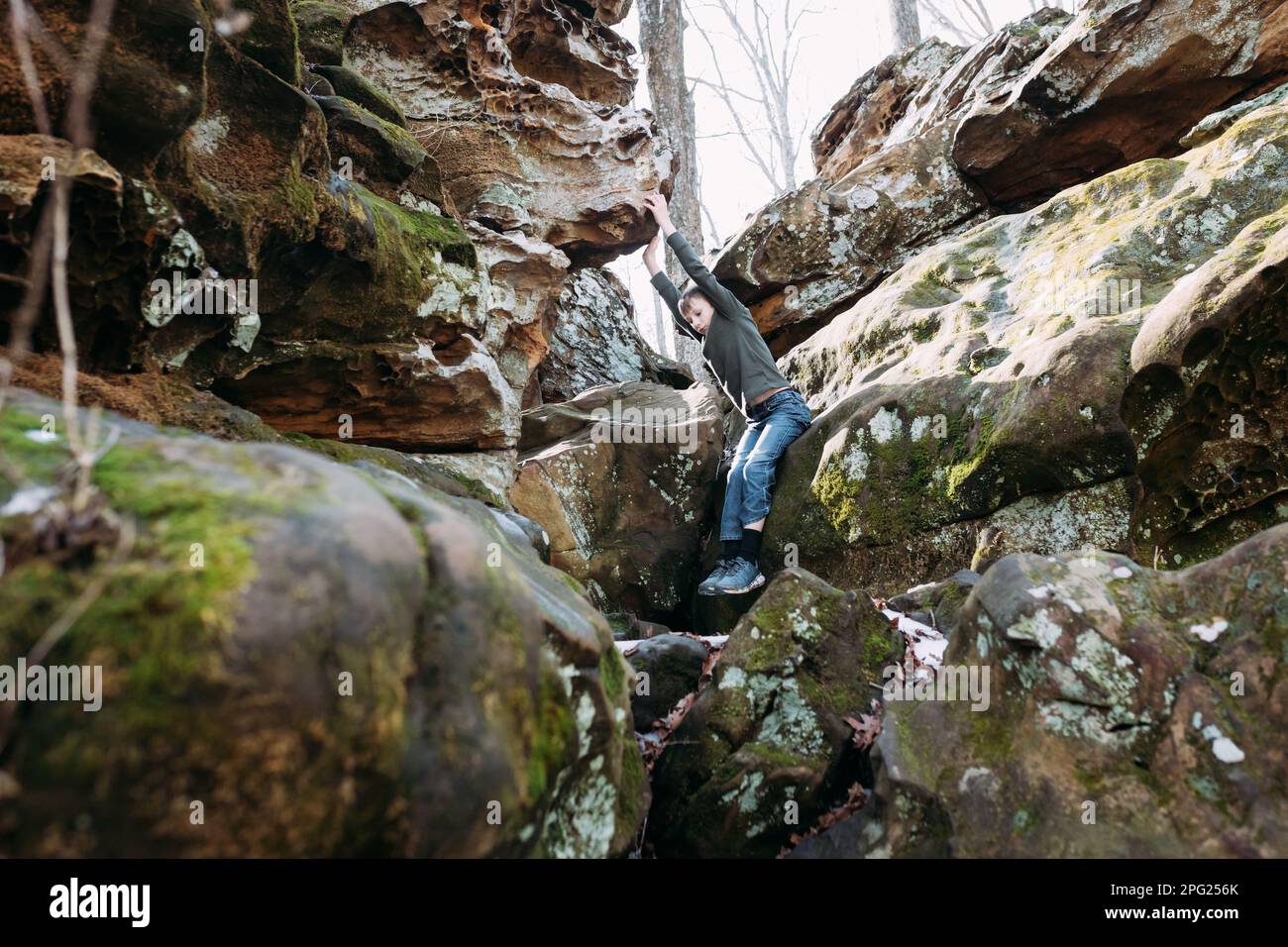 Child climbing on boulders on forest hike Stock Photo - Alamy