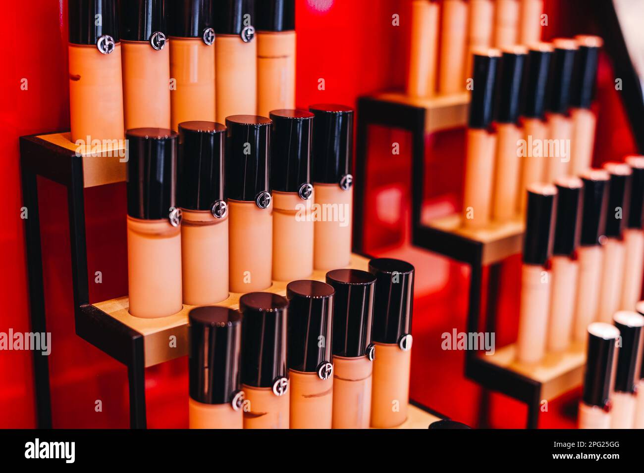 Mock up beige tubes of face foundation on a red stand in a store. The ...