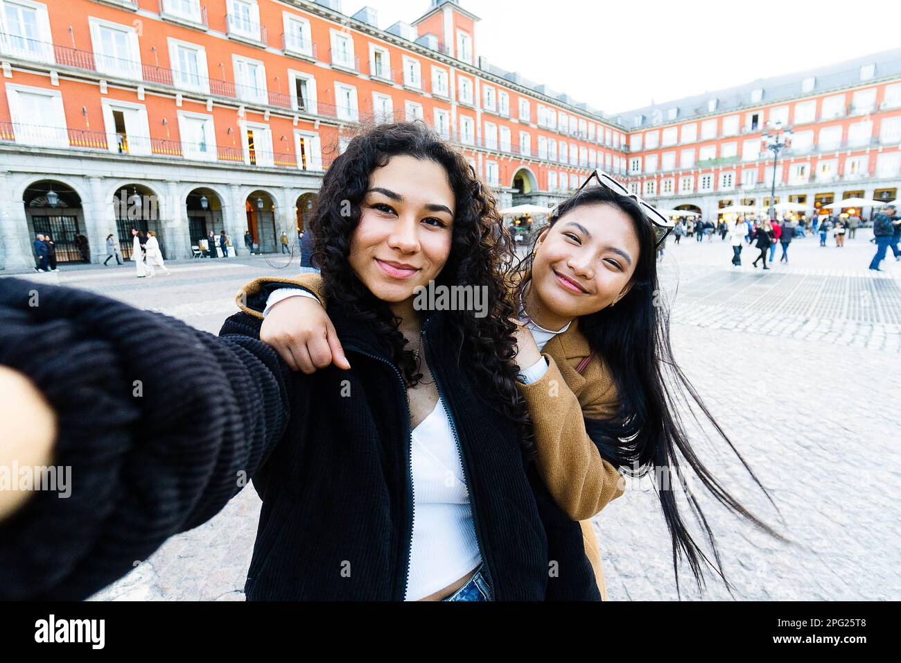 Stock photo of happy friends taking photo with phone visiting city ...