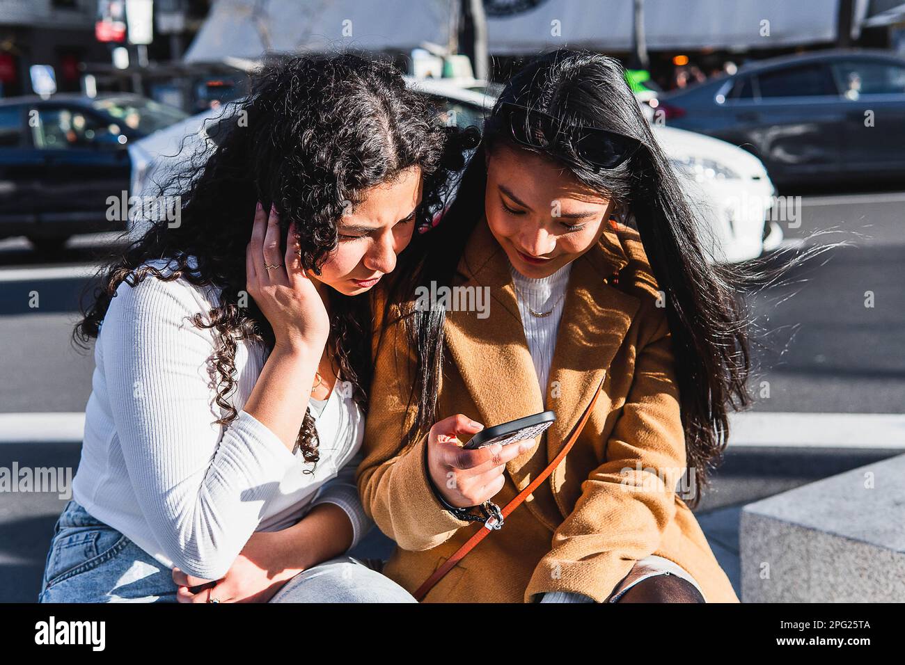 Stock photo of a two friends looking at there phone chatting Stock ...