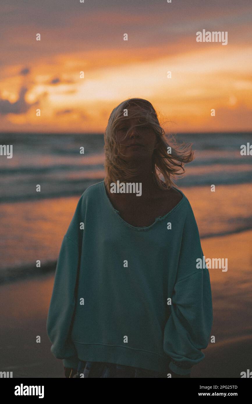 Woman on the ocean watching the sunset. Film, grain Stock Photo - Alamy