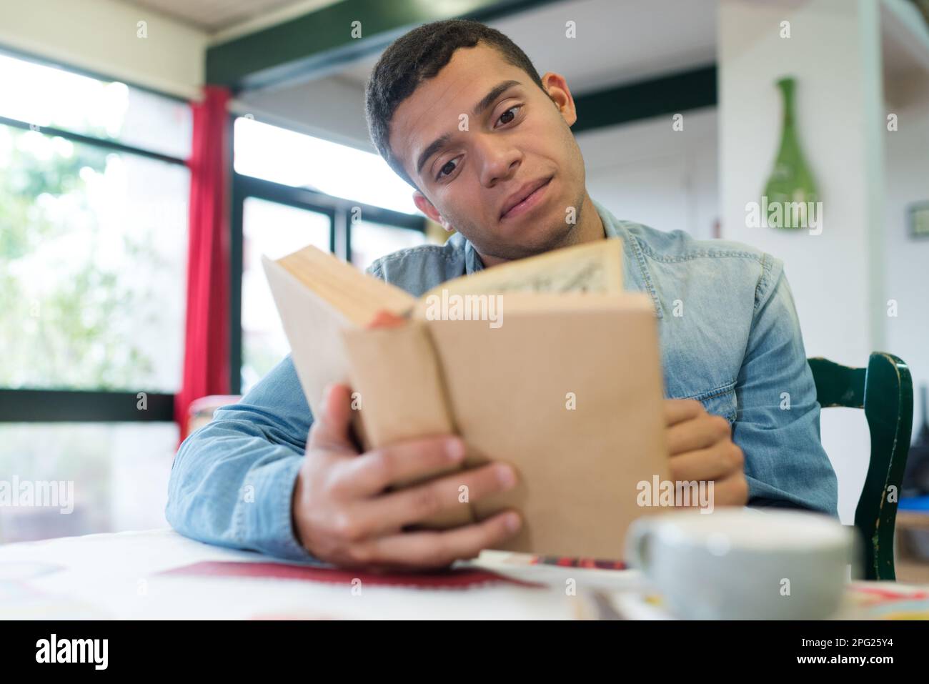 portrait of a confident handsome man reading a book Stock Photo - Alamy