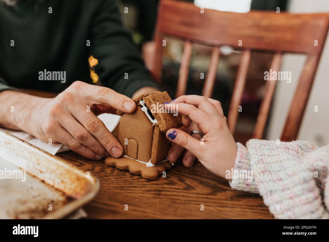 Father and daughter work together to build gingerbread house Stock ...