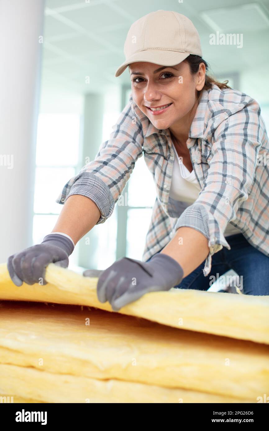 female contractor installing rockwool insulation Stock Photo - Alamy