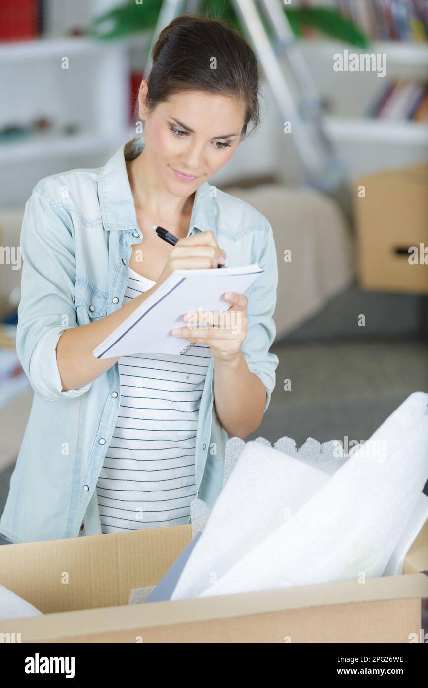 happy woman checking stuff in cardboard box Stock Photo - Alamy