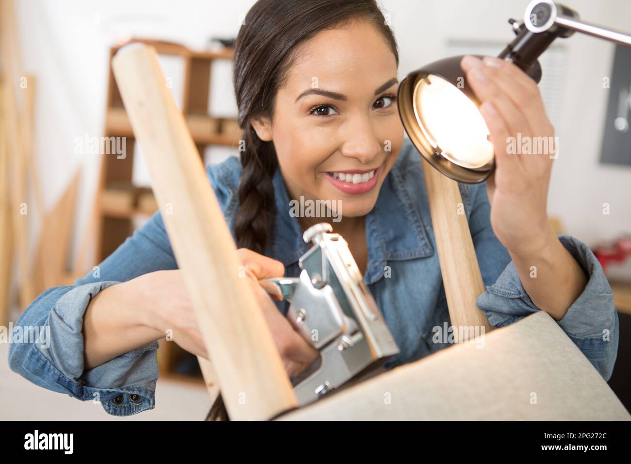 a happy woman fixing a chair leg Stock Photo - Alamy