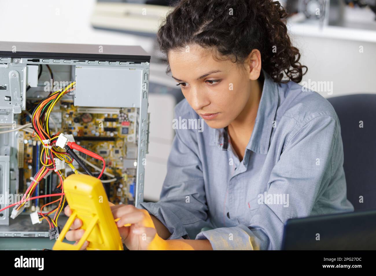 woman checking computer with a multimeter Stock Photo - Alamy