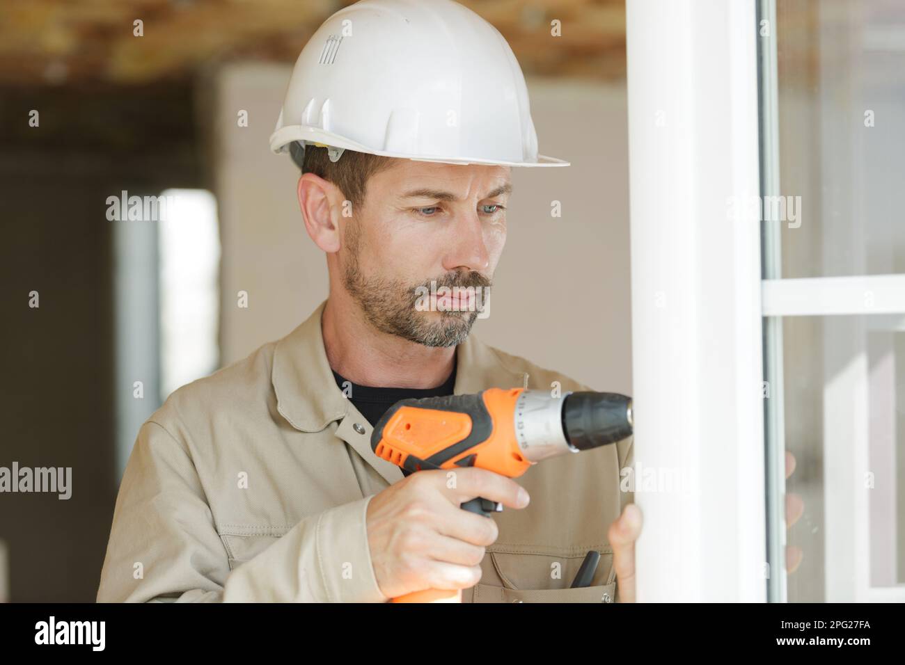 a man drilling a window frame Stock Photo - Alamy