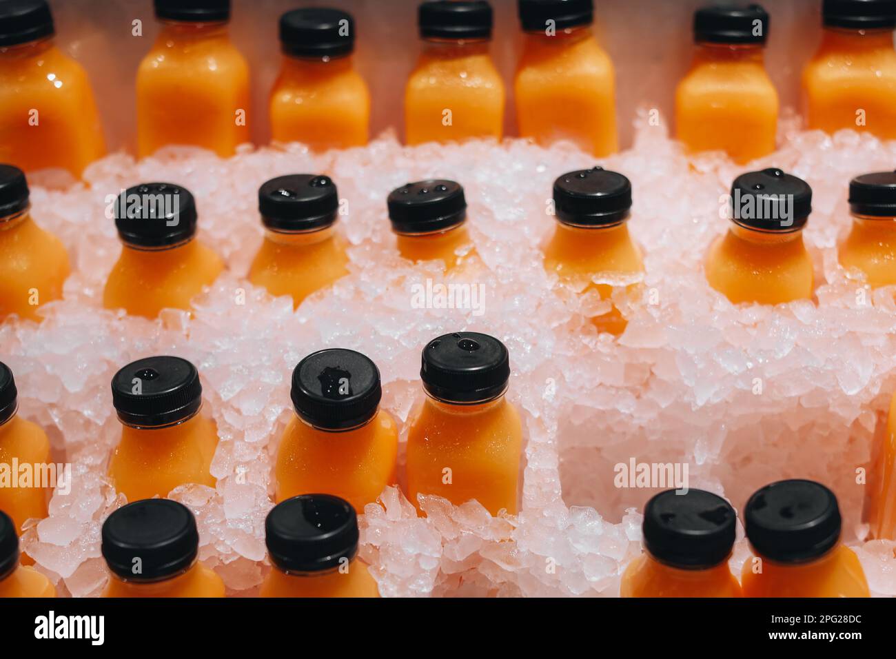 Plastic bottles with fresh orange juice in ice Stock Photo - Alamy