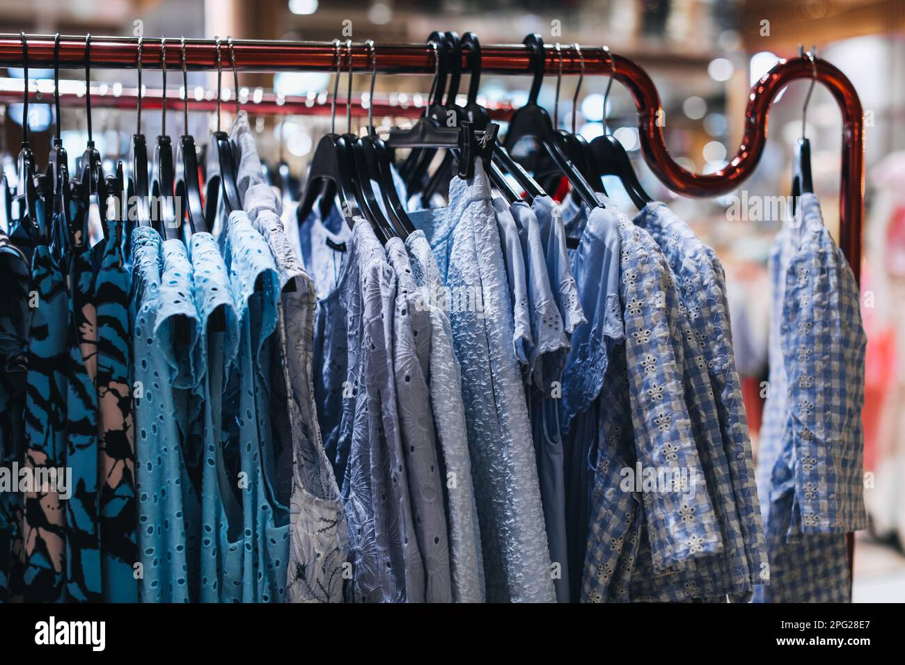 Blue women's clothes hanging on a hanger in a row. Fashion collection ...