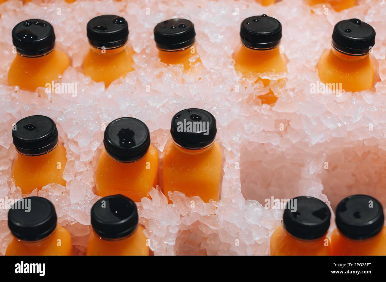 Plastic bottles with fresh orange juice in ice Stock Photo - Alamy