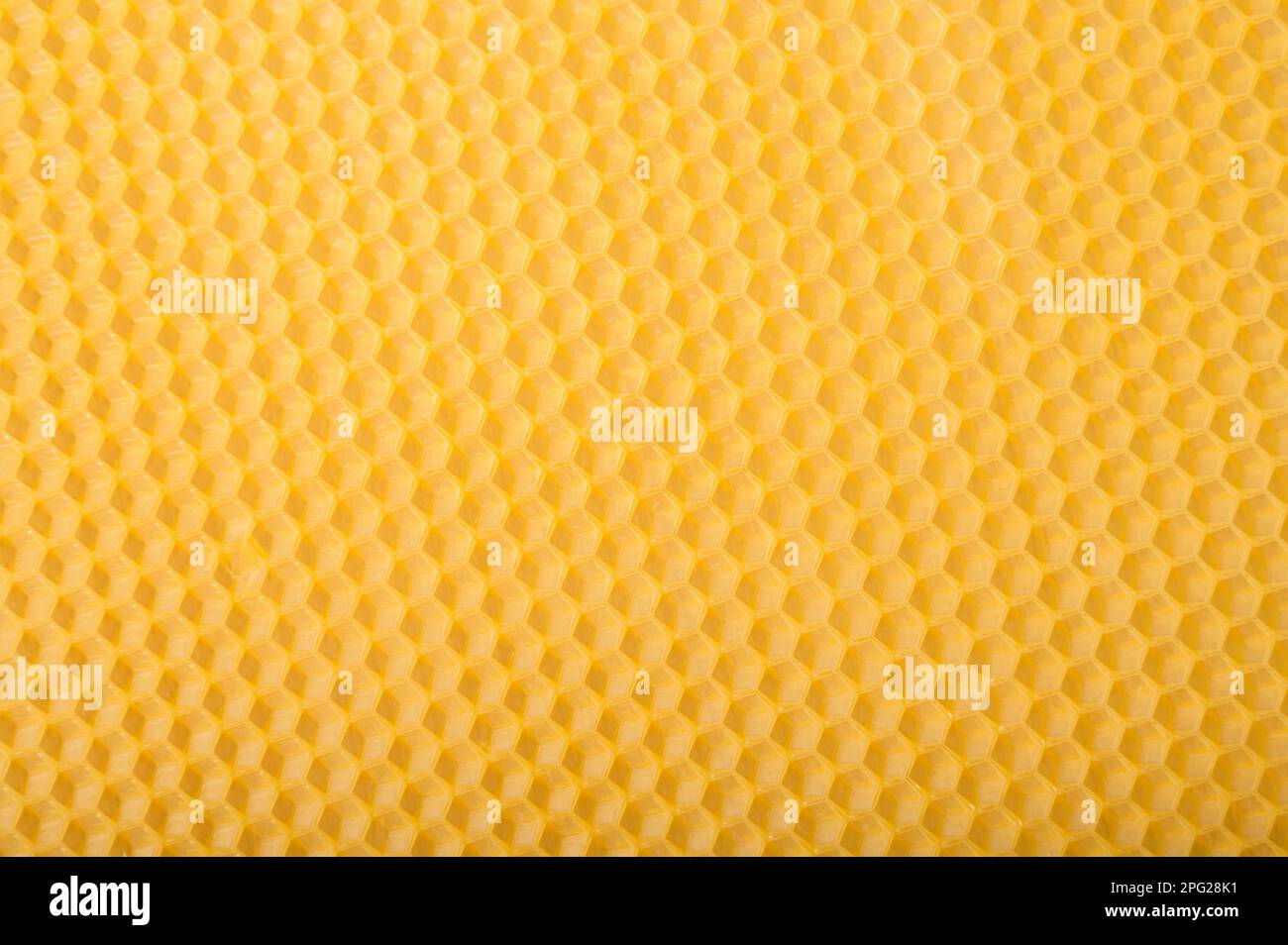 Beeswax honeycomb candle sheet close up background Stock Photo - Alamy