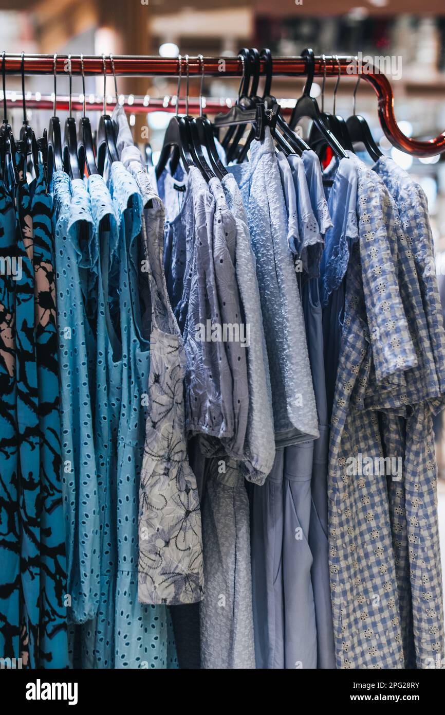 Blue women's clothes dresses hanging on a hanger in a row. Fashion ...