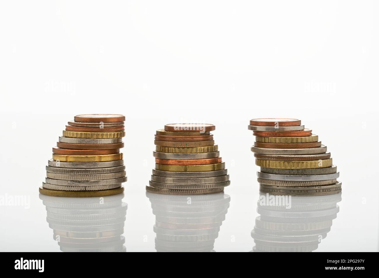 Three stacks of coins of silver, brass, nickel and bronze in colour ...