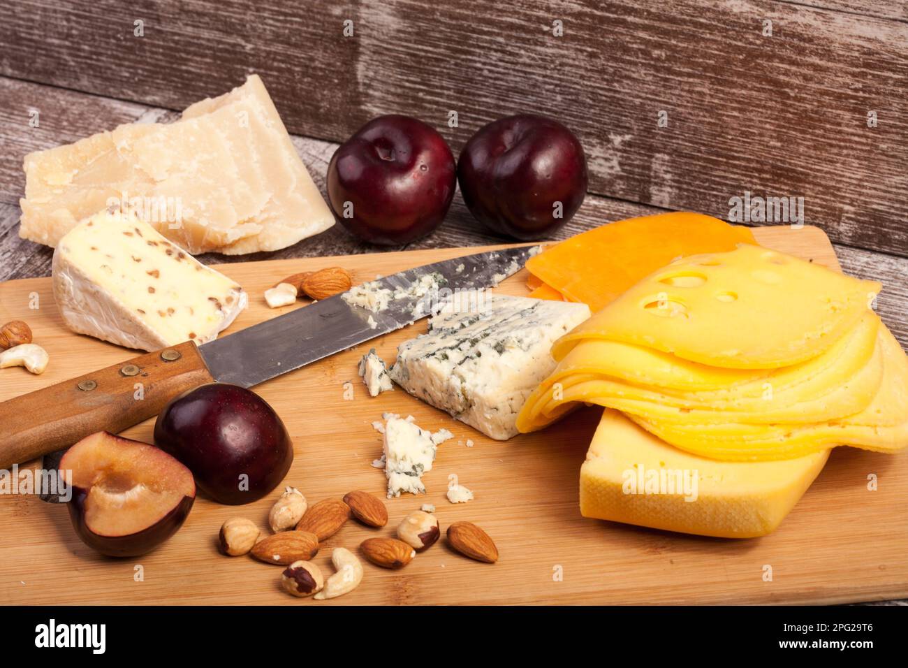 Nuts, cheese and fruits on wooden background in studio photo Stock ...